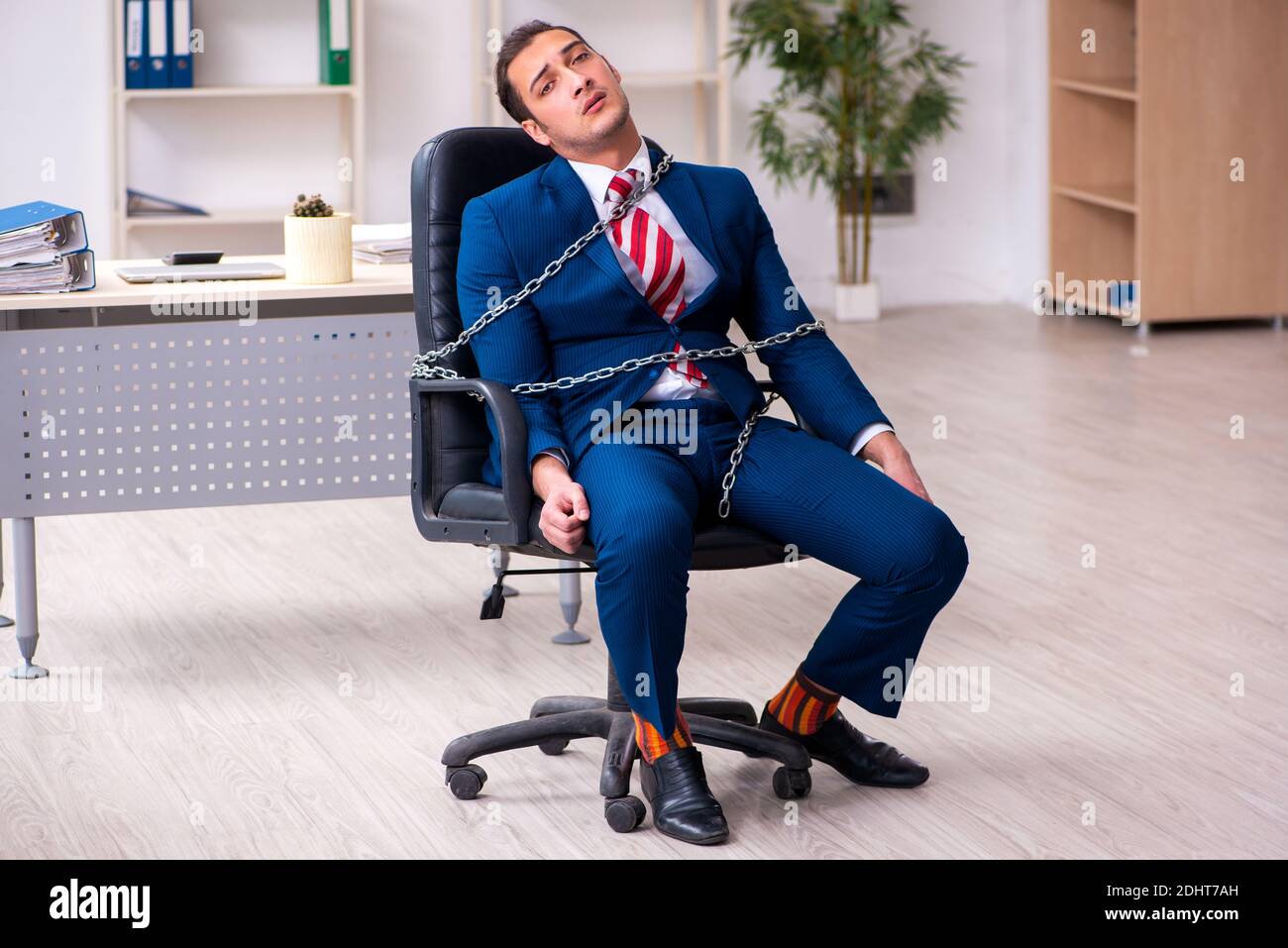 Chained employee working in the office Stock Photo - Alamy