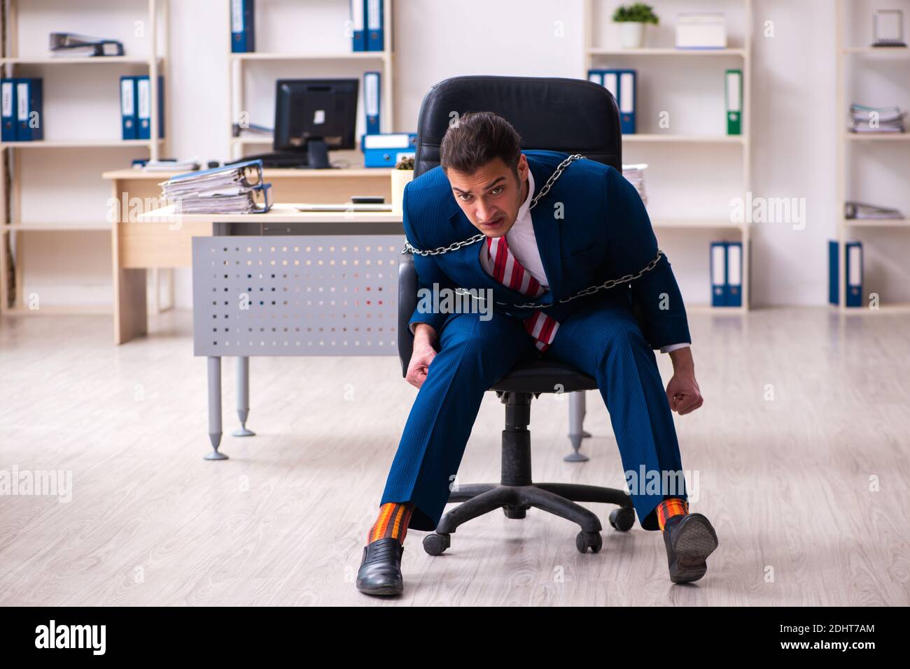 Chained employee working in the office Stock Photo - Alamy