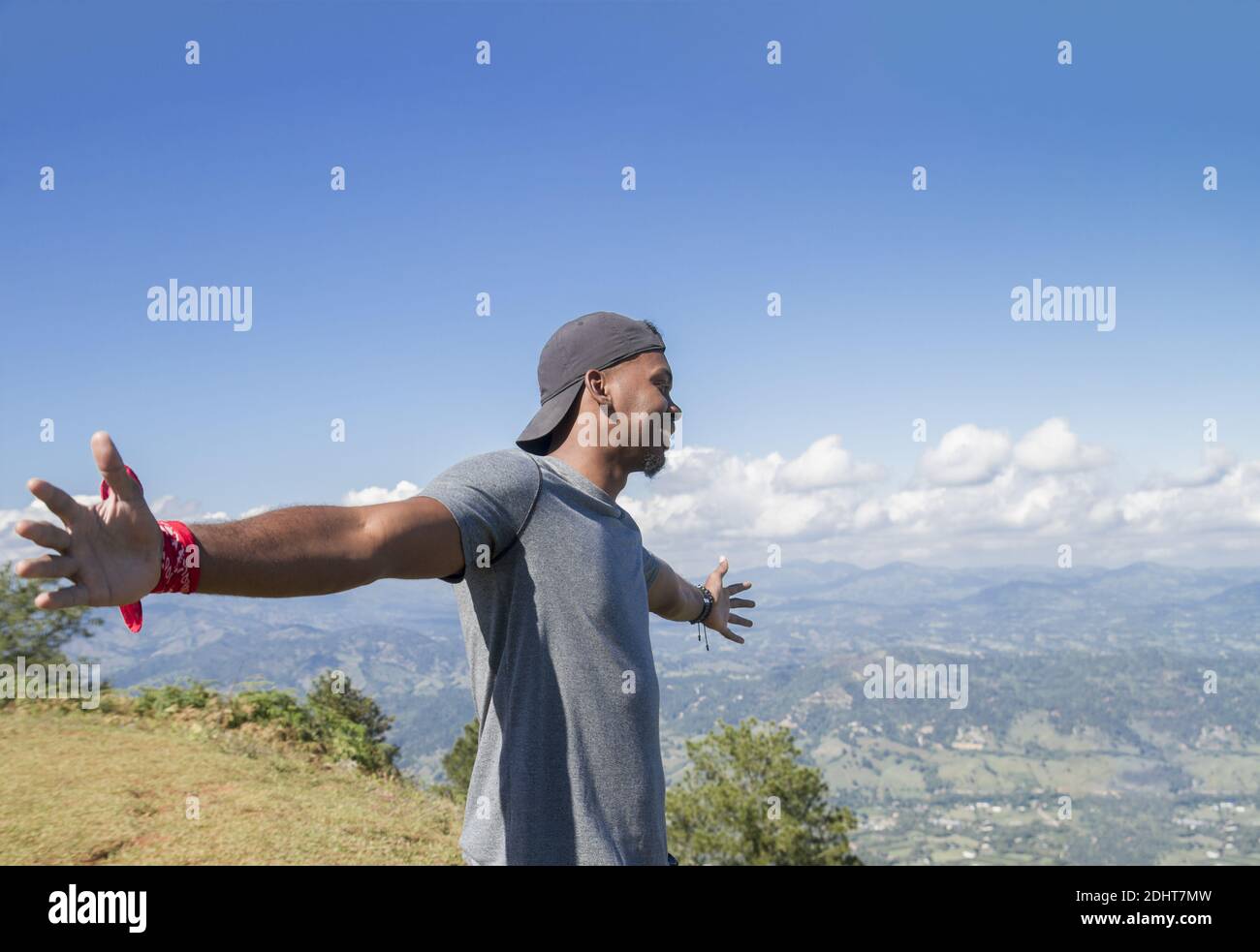 half body view of one happy black skinned young man wearing hat or cap ...