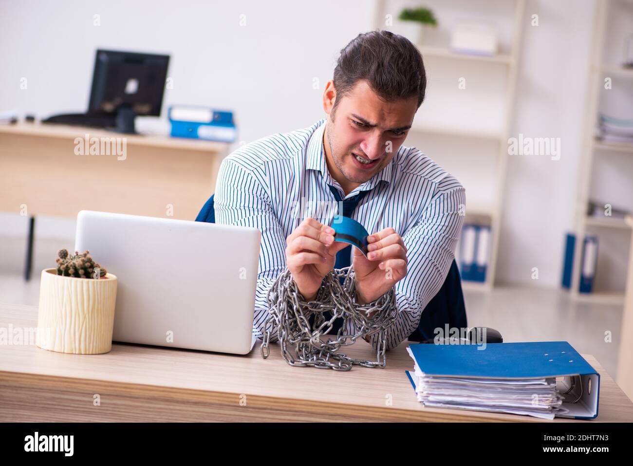 Chained employee working in the office Stock Photo - Alamy