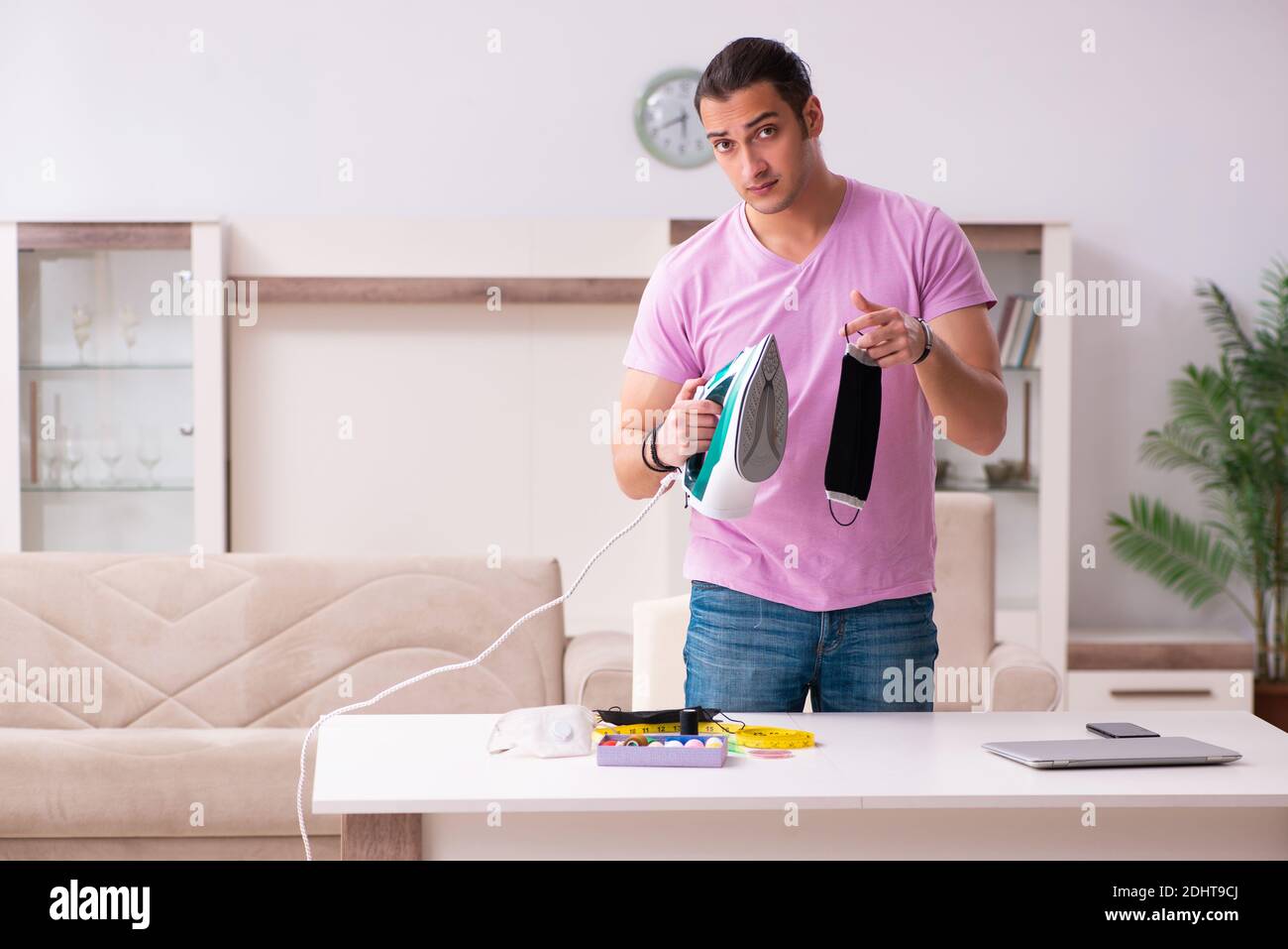 Male tailor ironing mask during pandemic Stock Photo - Alamy