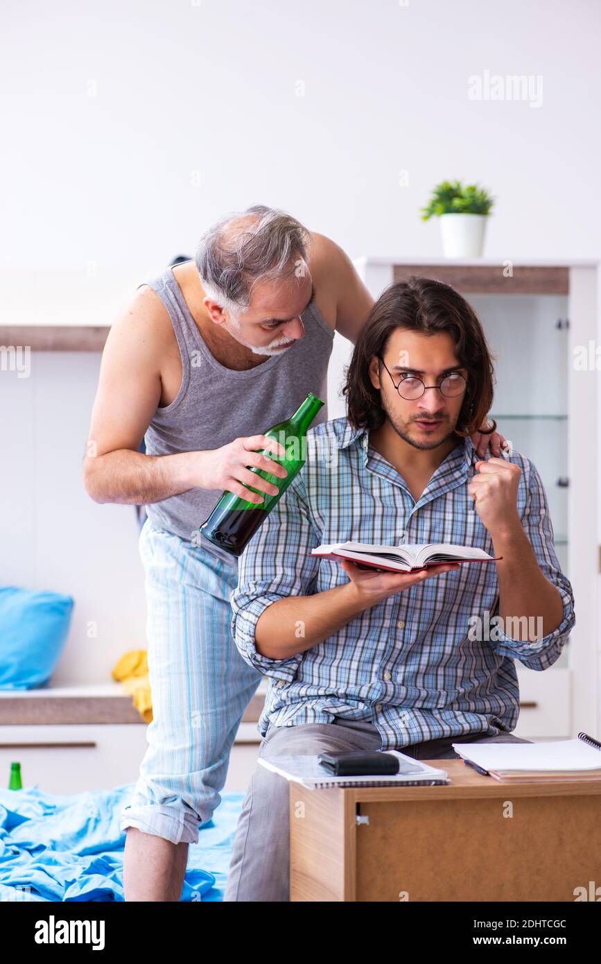 Young son student and dad alcoholic at home Stock Photo - Alamy