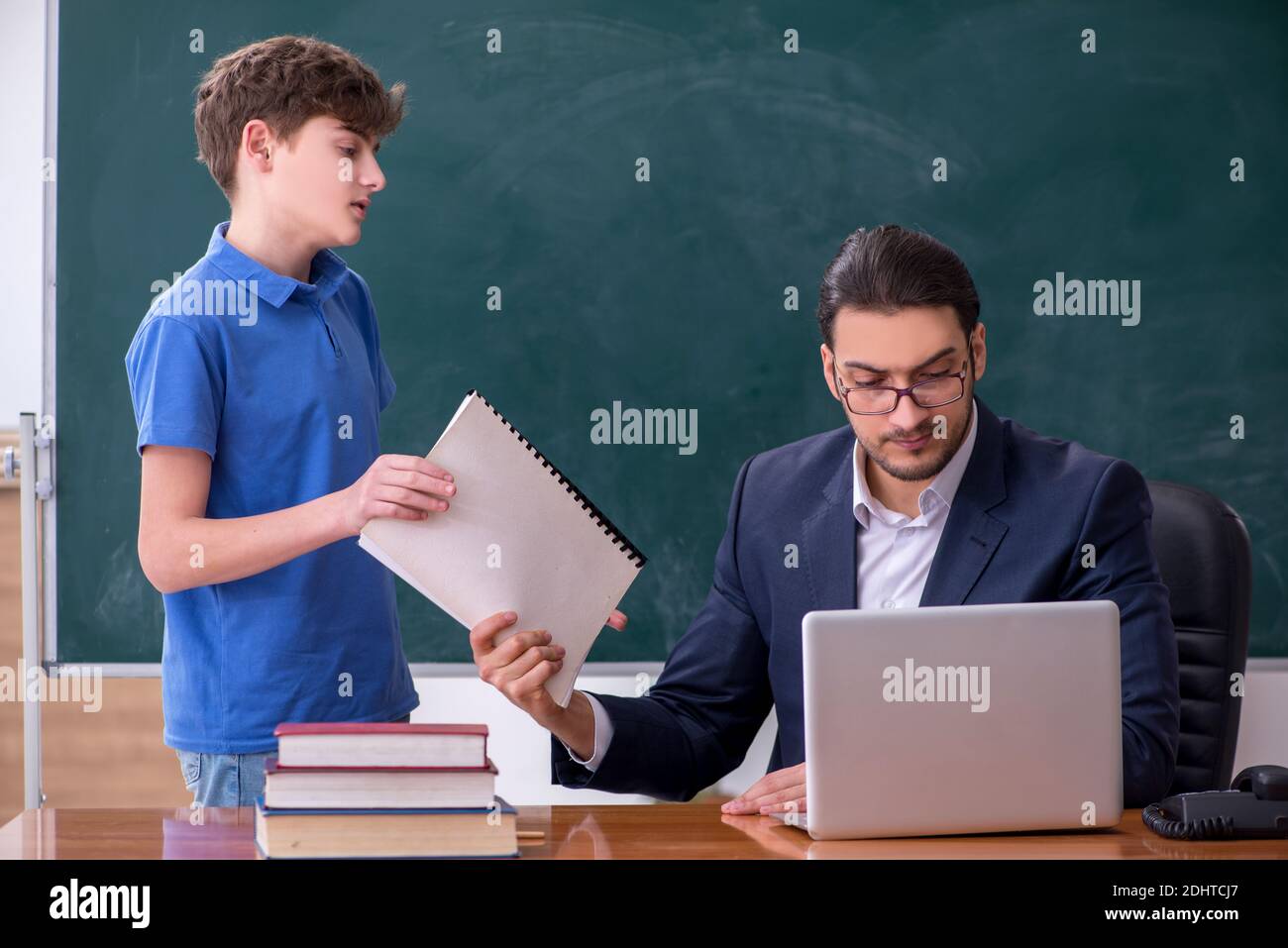 Male teacher and schoolboy in the classroom Stock Photo - Alamy