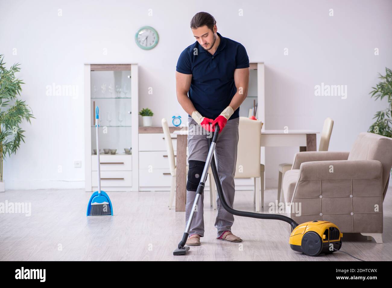 Young leg injured contractor cleaning house Stock Photo - Alamy