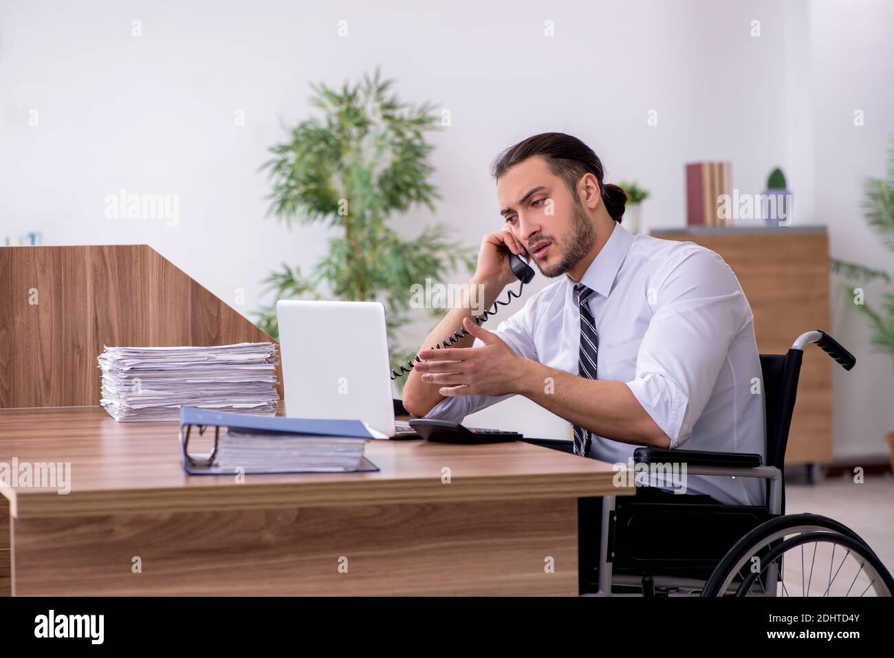 Young disabled employee suffering at the workplace Stock Photo - Alamy