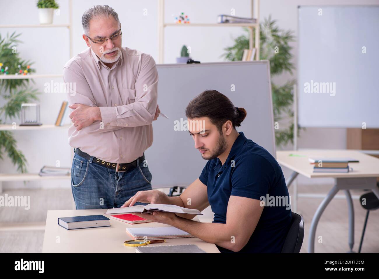 Old teacher and young student in the classroom Stock Photo - Alamy