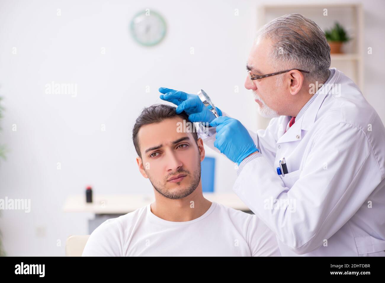 Young man visiting old doctor dermatologist Stock Photo - Alamy