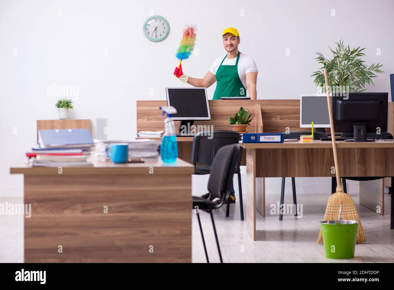 Young contractor cleaning the office Stock Photo - Alamy
