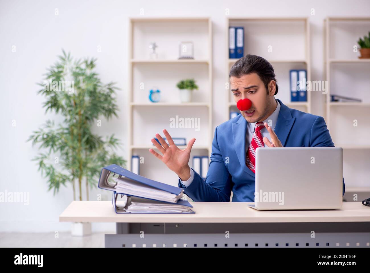Funny employee clown working in the office room Stock Photo - Alamy