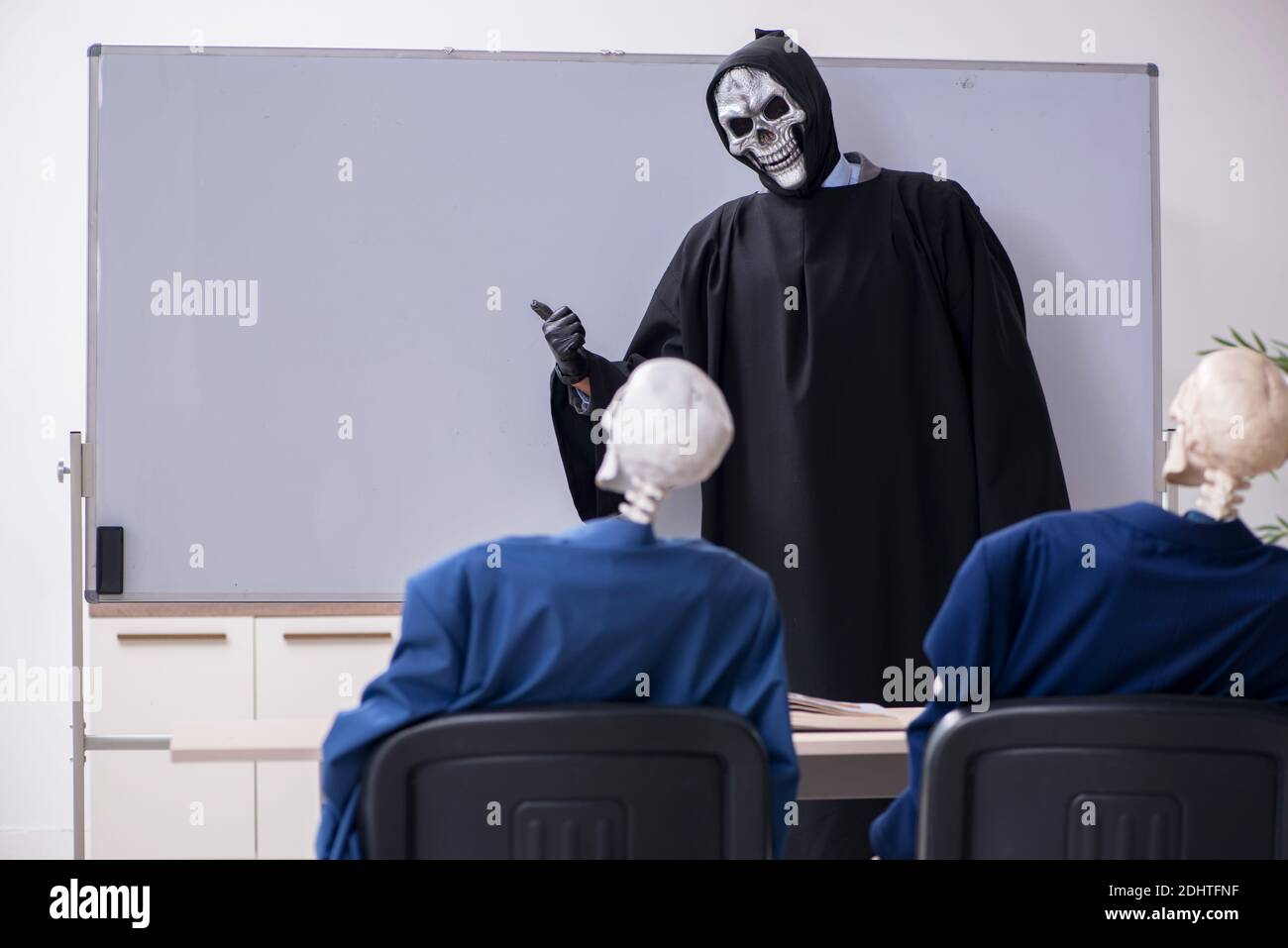 Funny business meeting with the devil and skeletons Stock Photo - Alamy