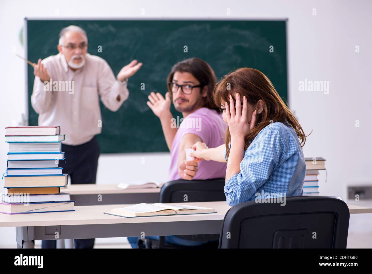 Old teacher and two students in the classroom Stock Photo - Alamy