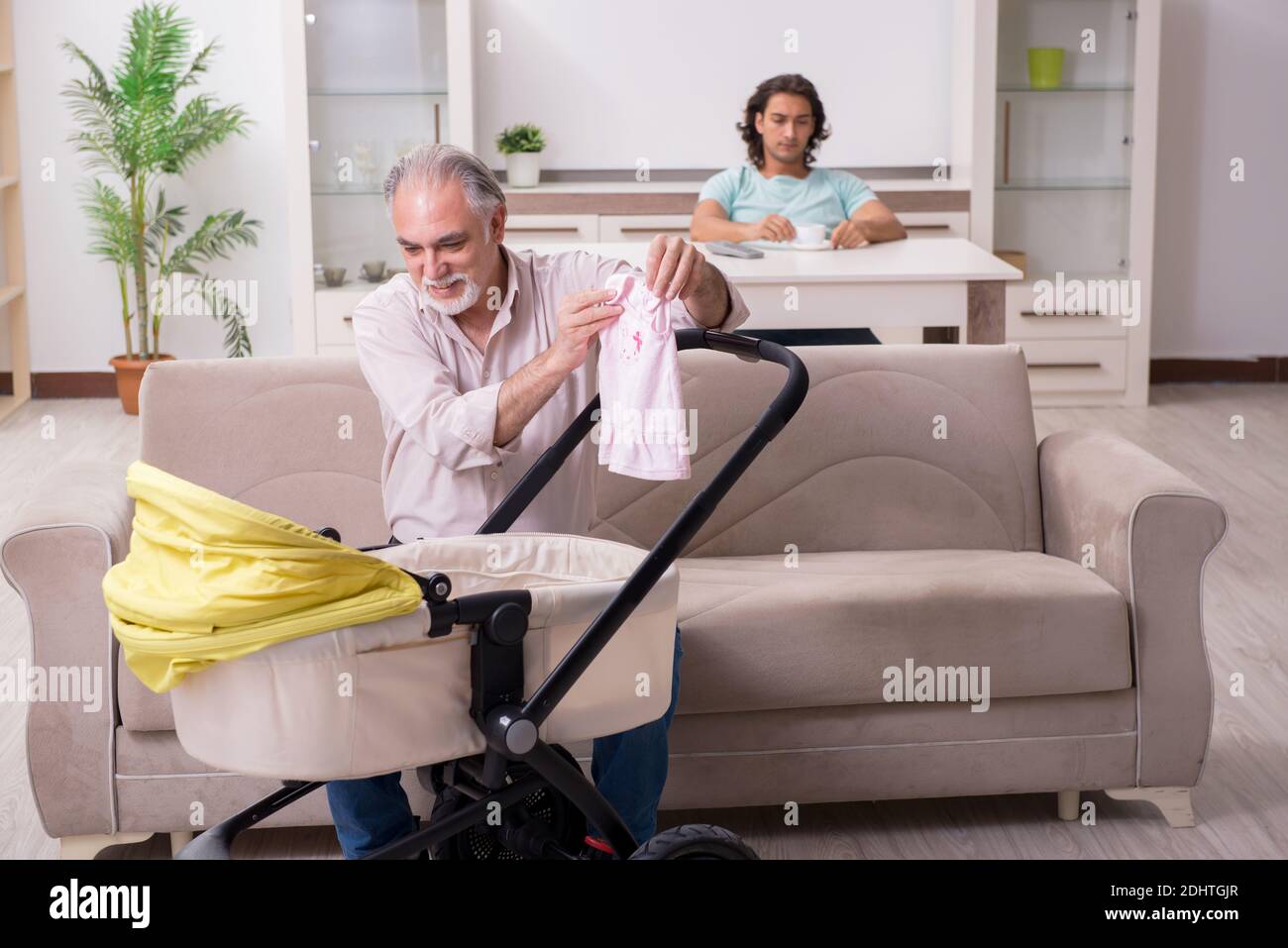 Old grandfather looking after newborn at home Stock Photo - Alamy