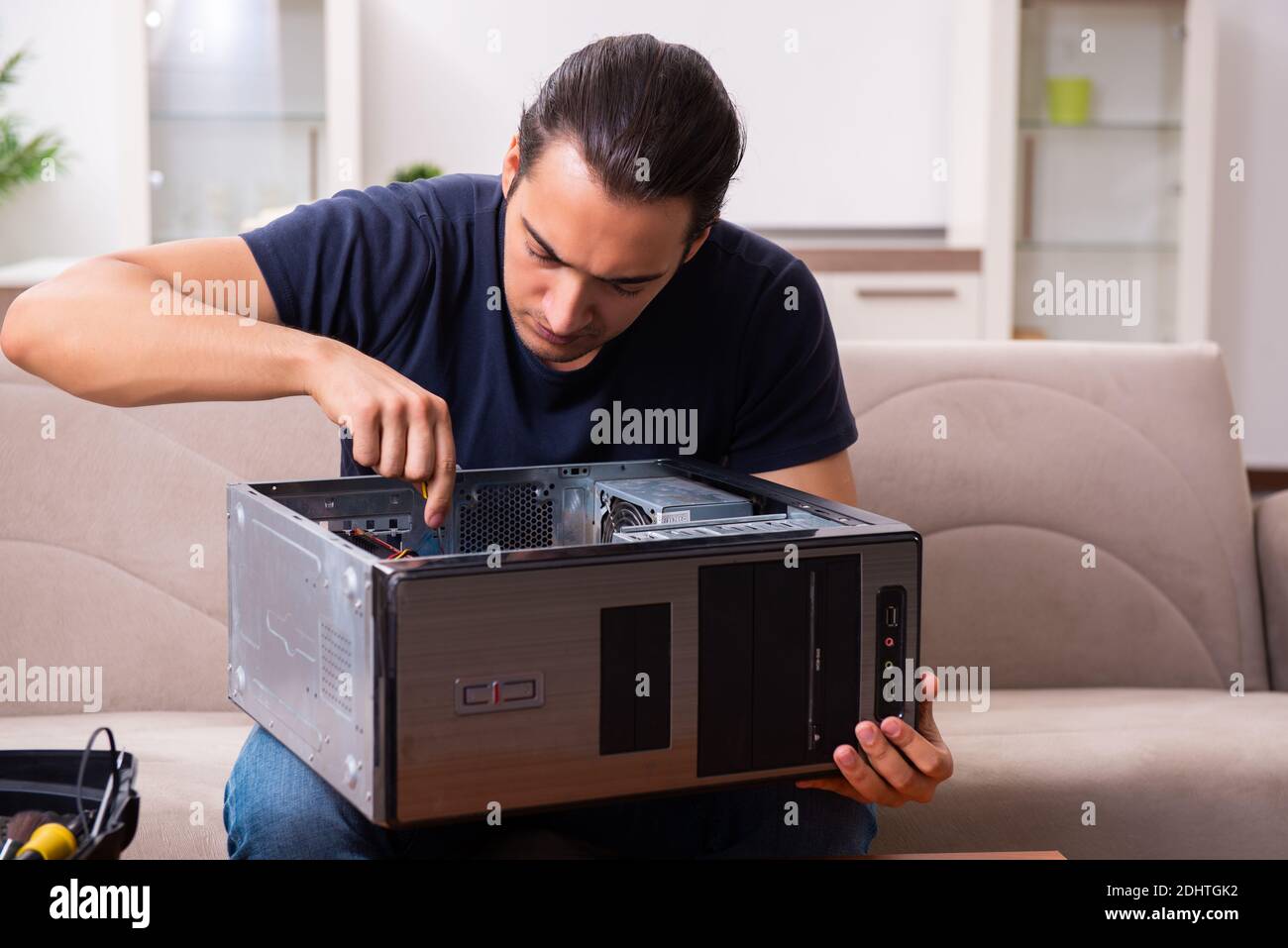 Young man repairing computer at the home Stock Photo - Alamy