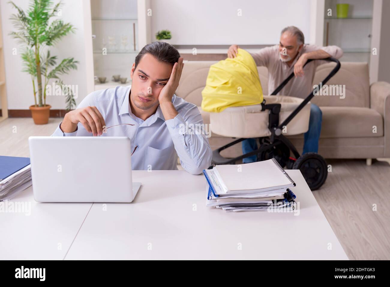 Old grandfather looking after newborn at home Stock Photo - Alamy