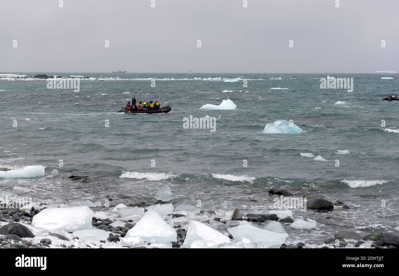 Eco-tourists in a zodiac with rough weather at Turret Point, King ...