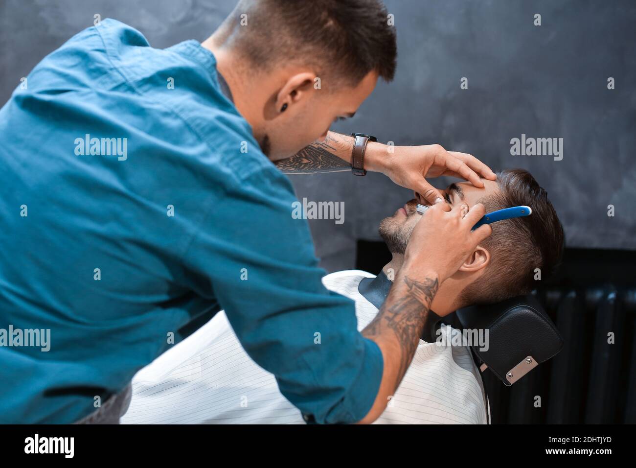 Hairdresser shaving client in barbershop Stock Photo - Alamy