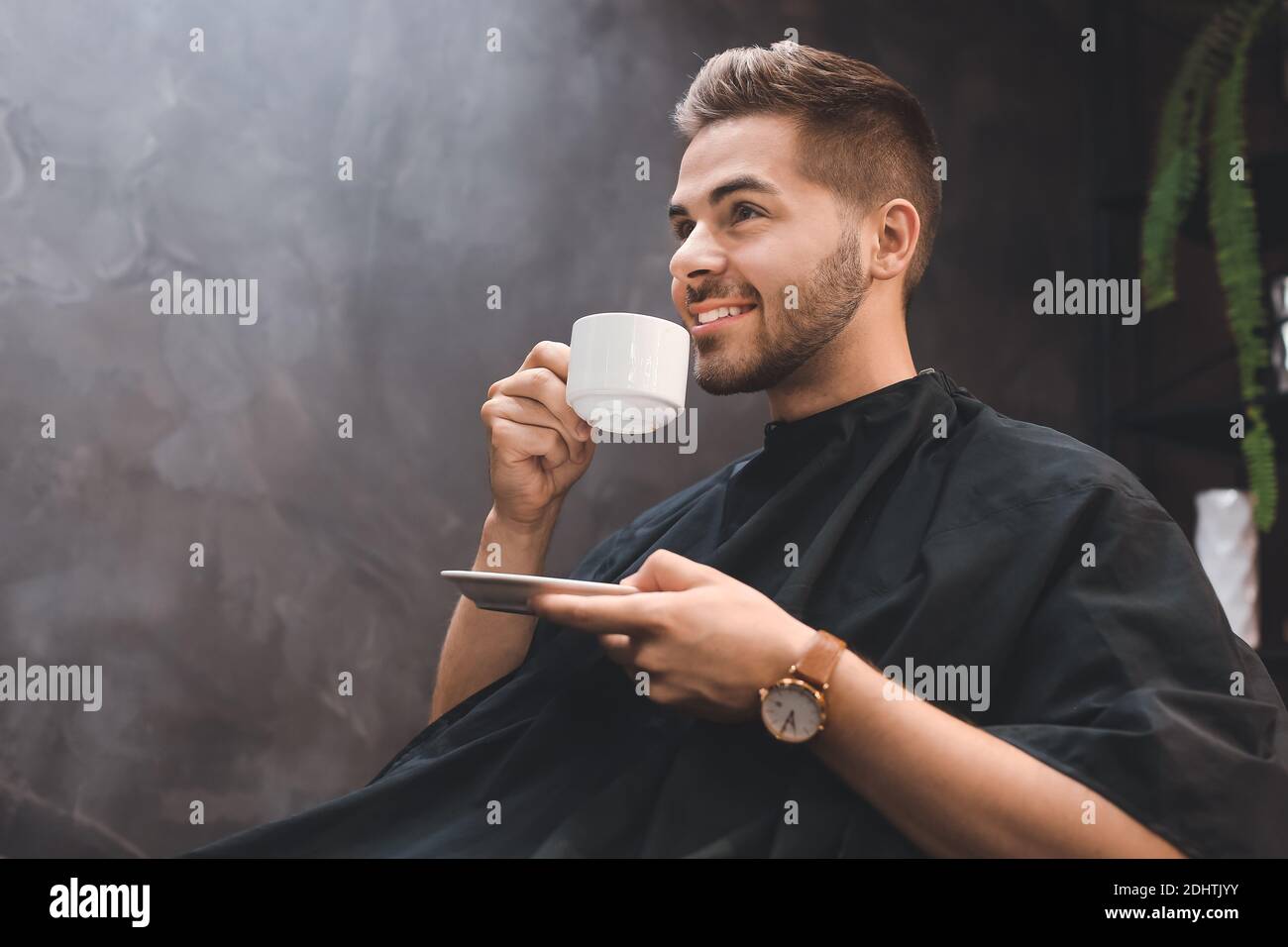 Handsome man drinking coffee in barbershop Stock Photo - Alamy