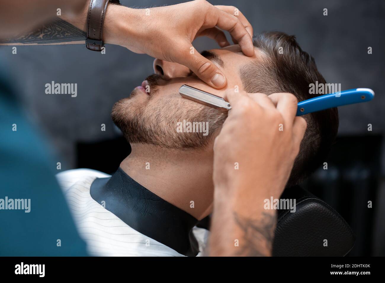 Hairdresser shaving client in barbershop Stock Photo - Alamy