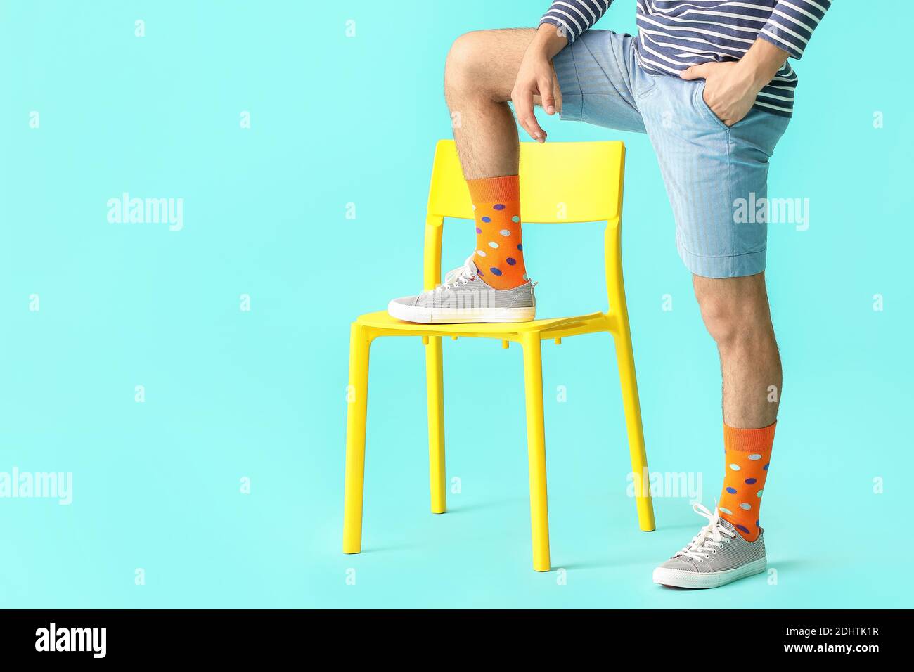 Young man in stylish shoes and orange socks on color background Stock ...