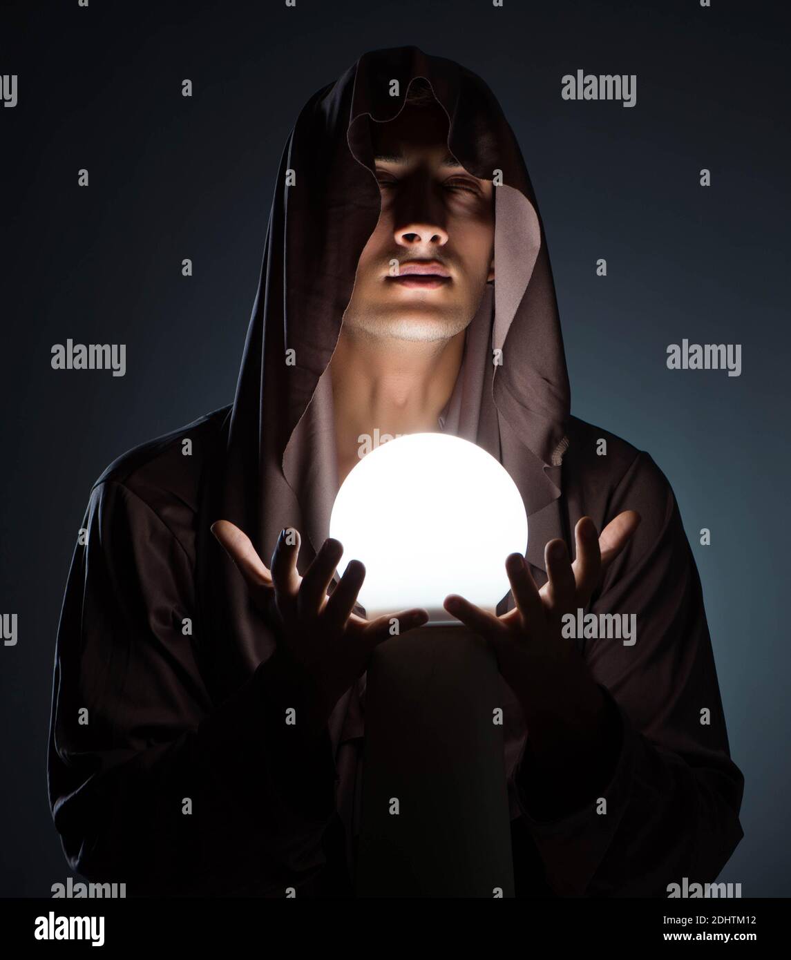 The young wizard with crystal ball in dark room Stock Photo - Alamy