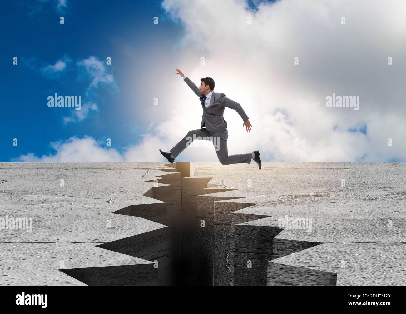 The businessman jumping over the cliff Stock Photo - Alamy