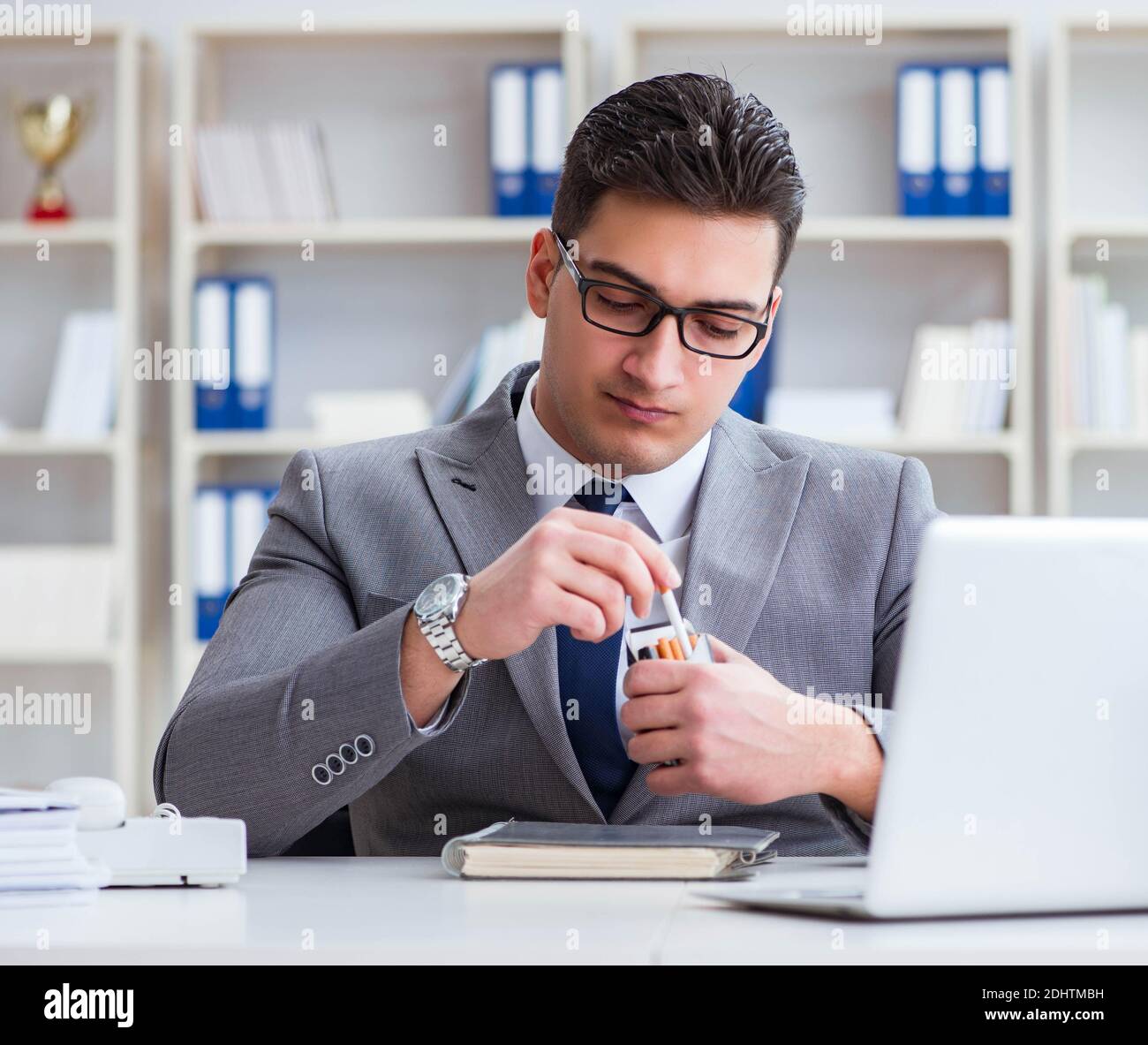 The businessman smoking in office at work Stock Photo - Alamy