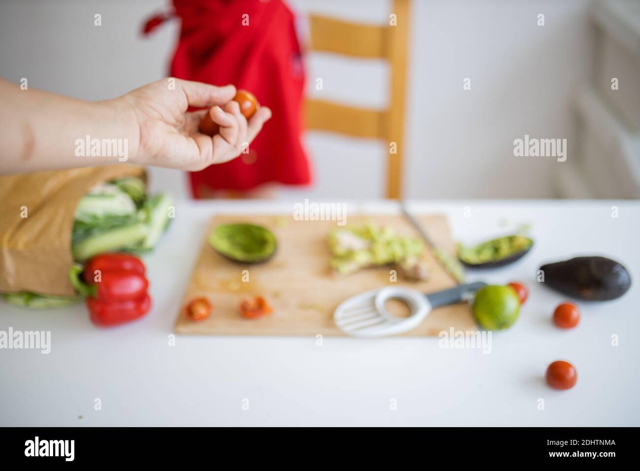 Female hand giving small tomatoes to a little girl at a table Stock ...