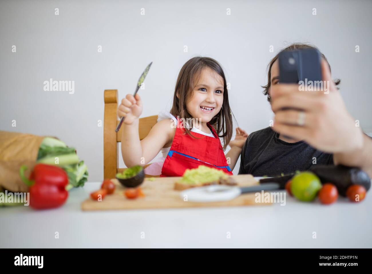 Father and daughter taking a selfie while making avocado toast Stock ...
