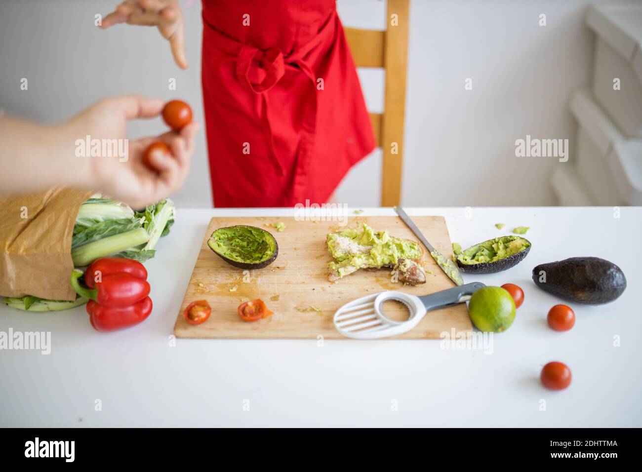 Female hand giving small tomatoes to a little girl at a table Stock ...