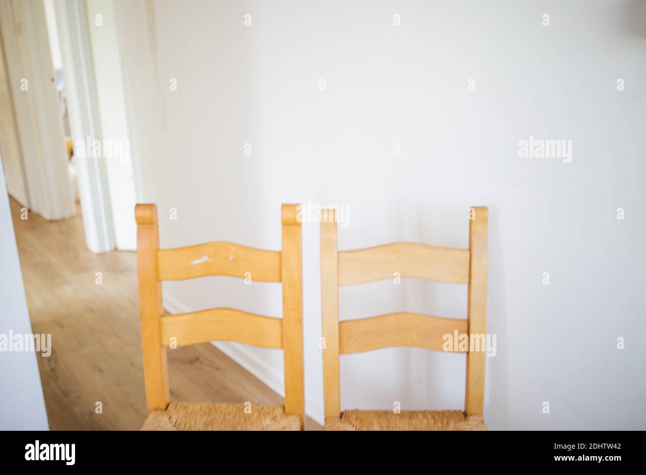 Two wooden chairs on a long empty hall Stock Photo - Alamy