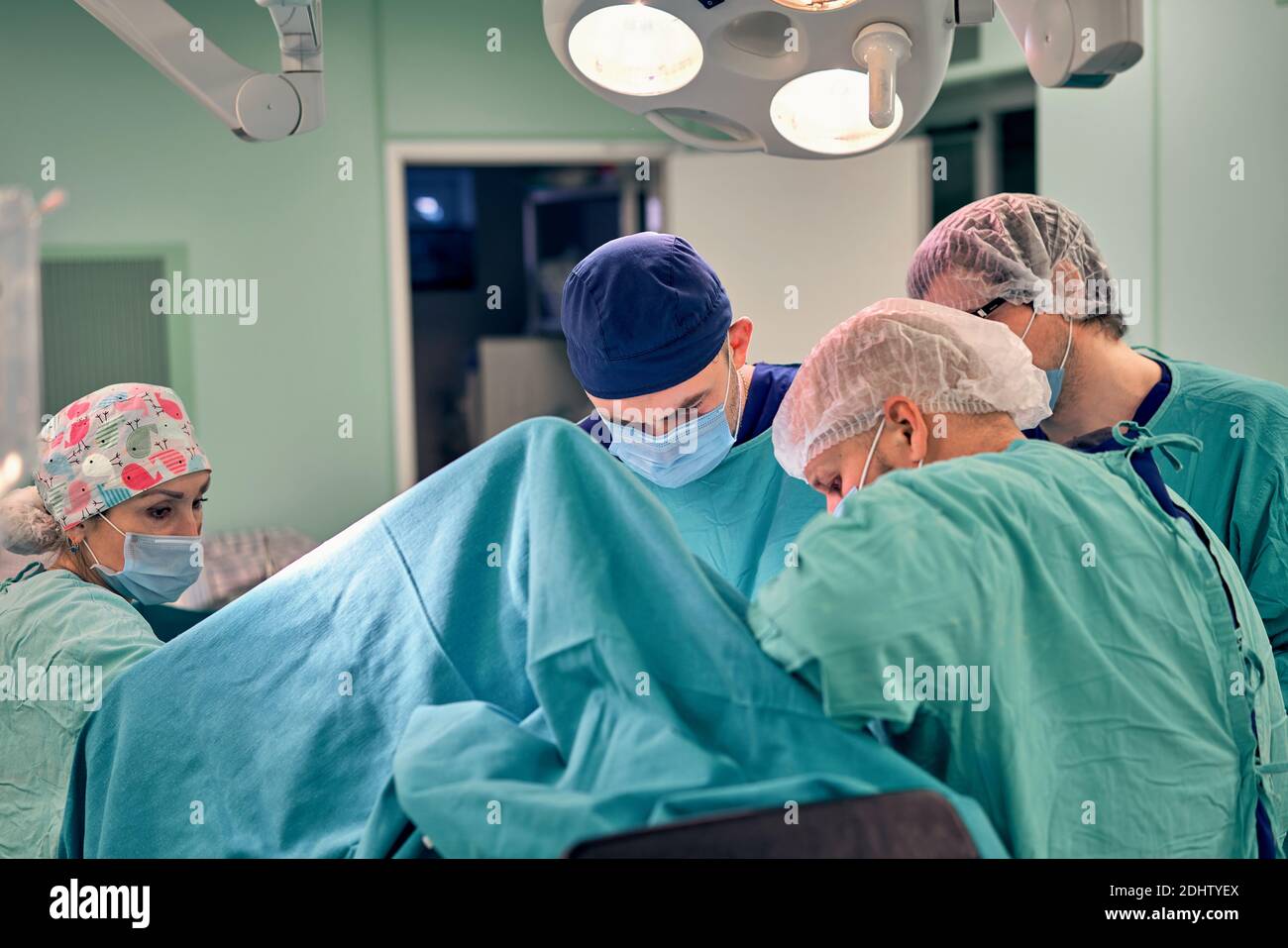 Physicians in Surgery looking down at patient Stock Photo - Alamy