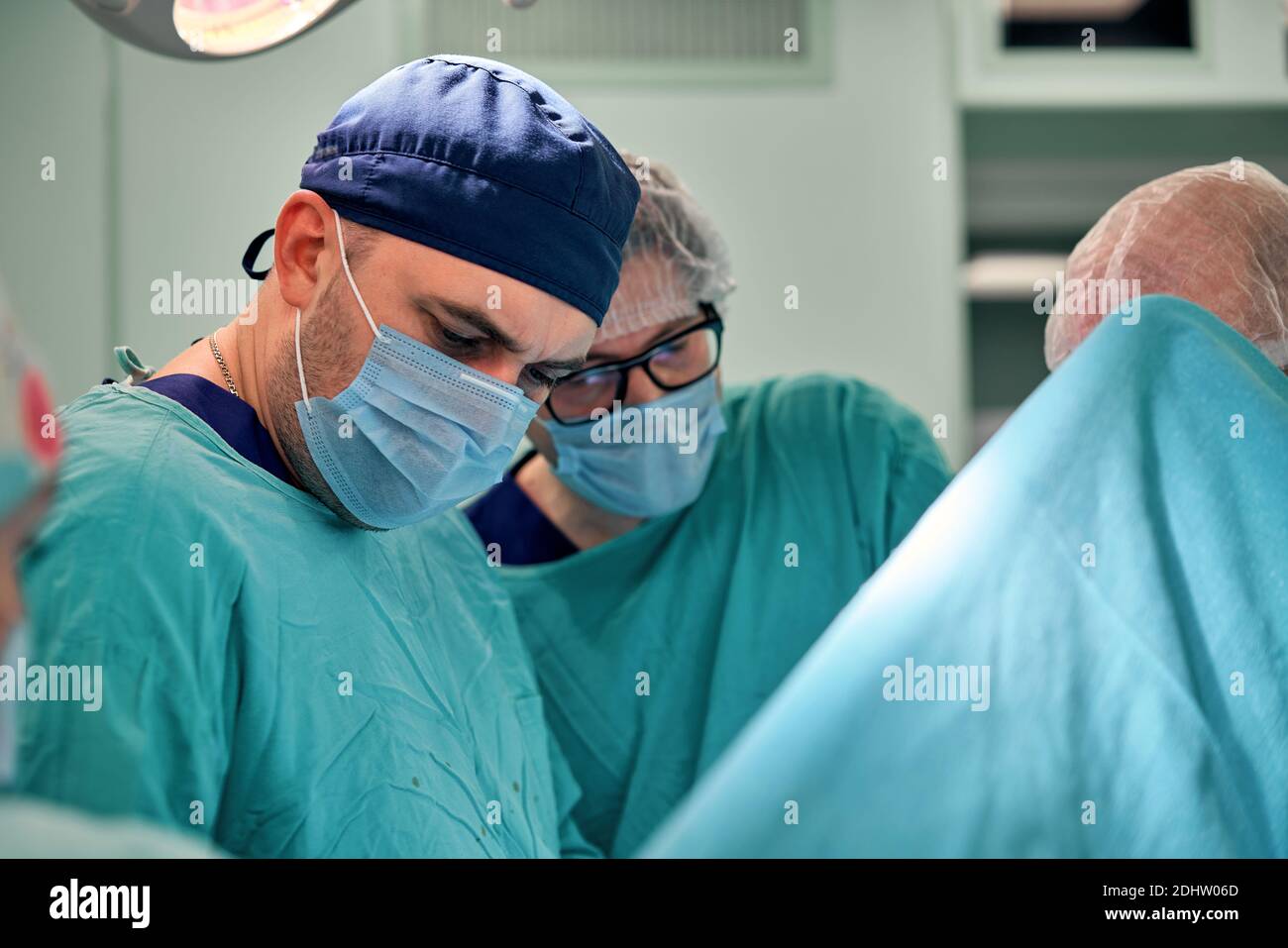 Physicians in Surgery looking down at patient Stock Photo - Alamy