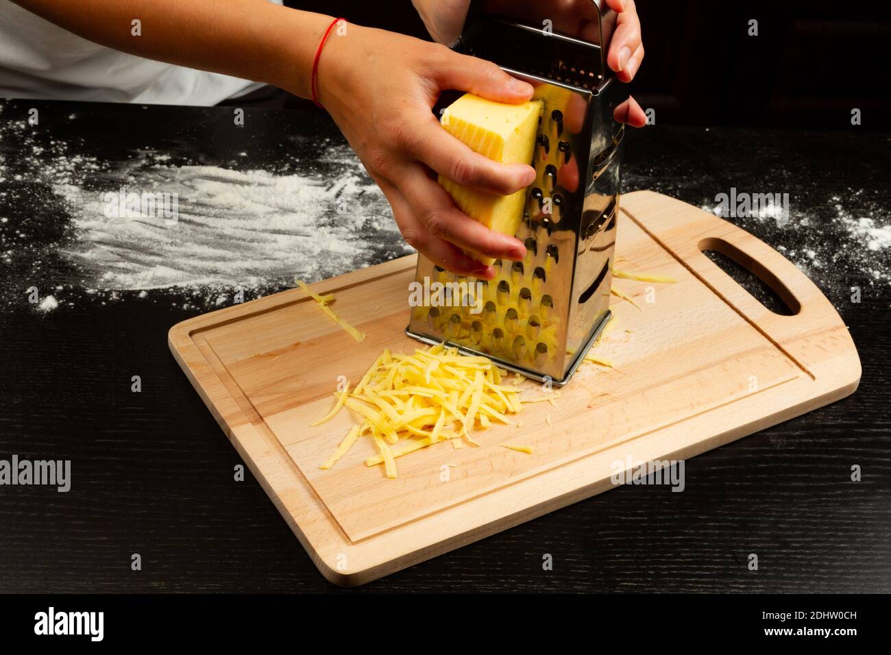 girl chef rubs fresh fragrant cheese on a grater for making homemade ...