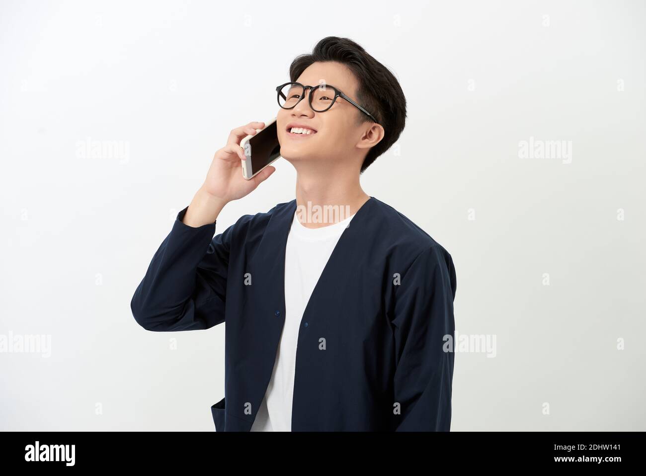 Portrait of a happy student talking on mobile phone over white ...