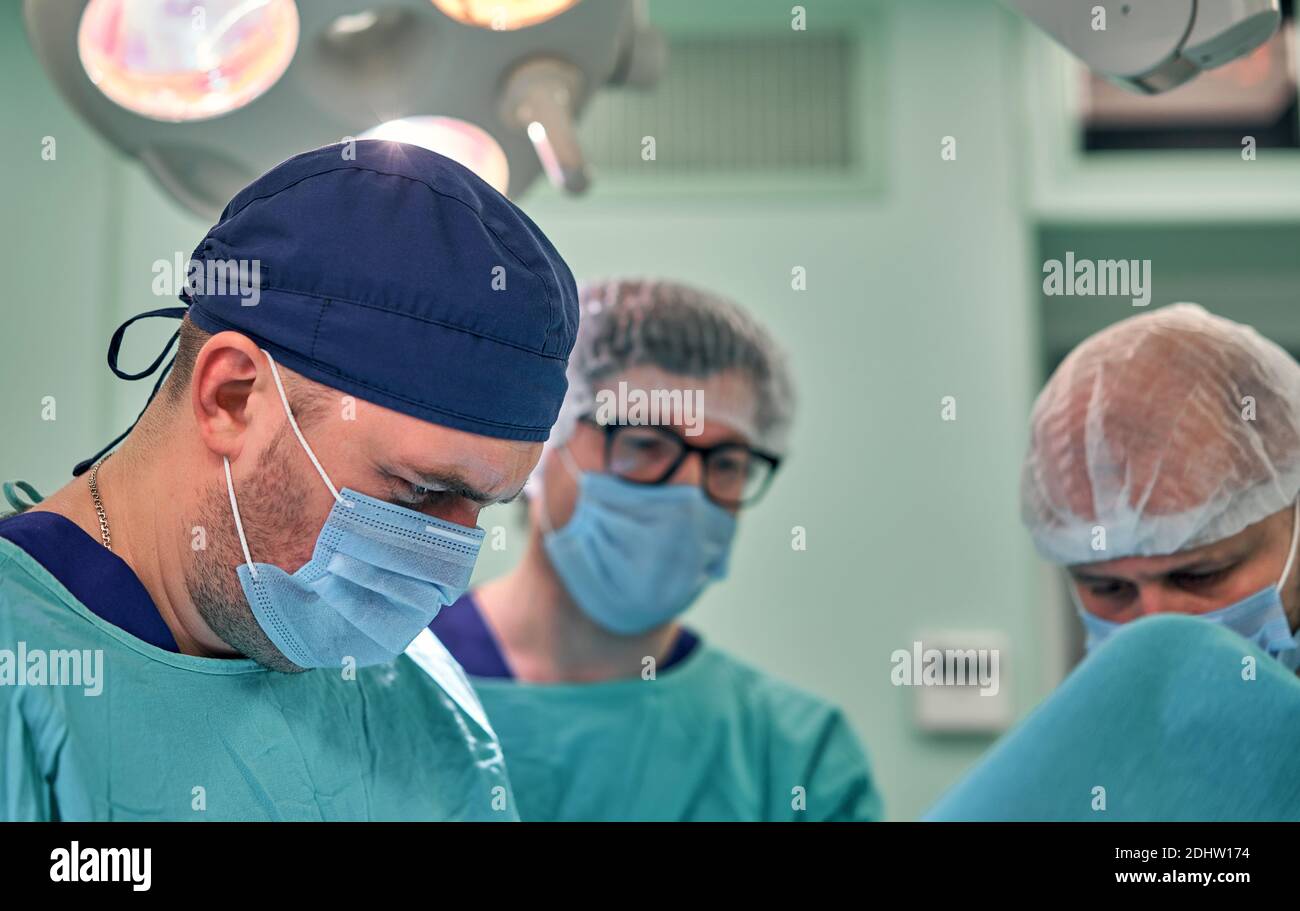 Physicians in Surgery looking down at patient Stock Photo - Alamy