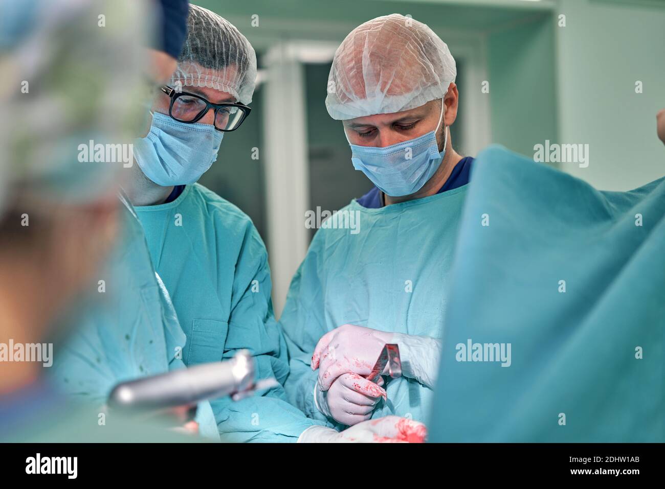Physicians in Surgery looking down at patient Stock Photo - Alamy