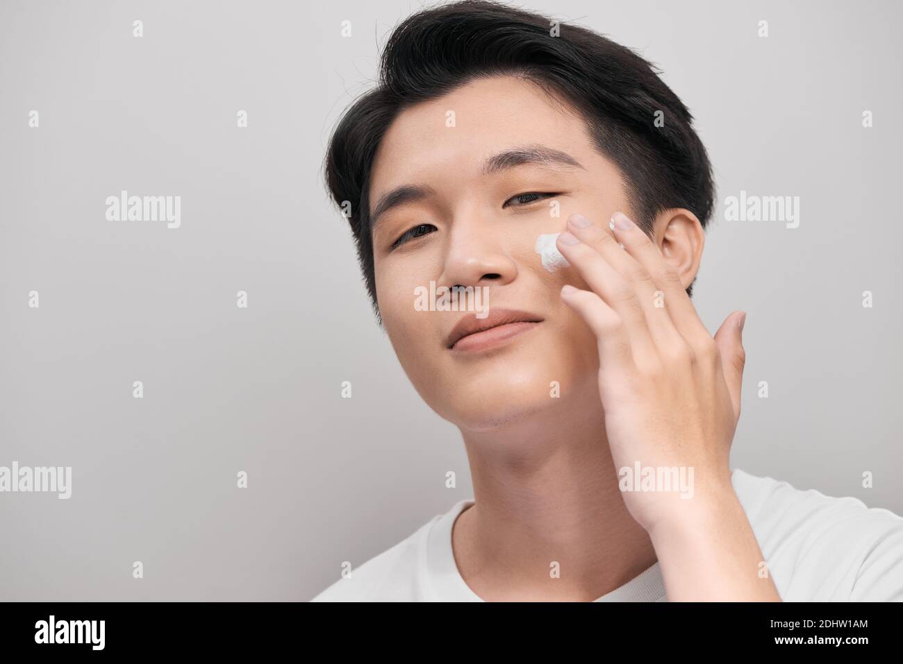 smiling man applying cream lotion on face Stock Photo - Alamy