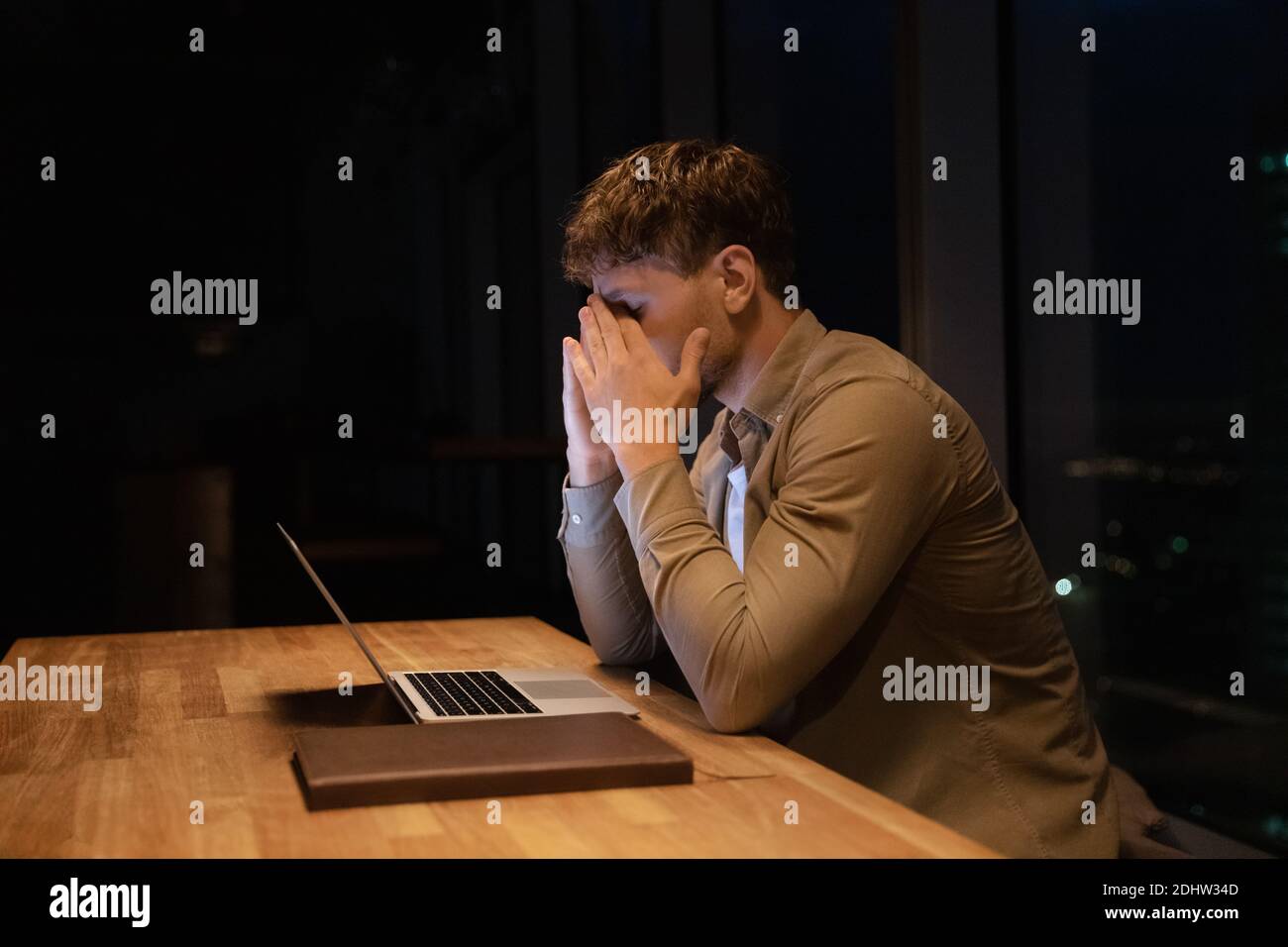 Tired male employee overwork in office at night Stock Photo - Alamy