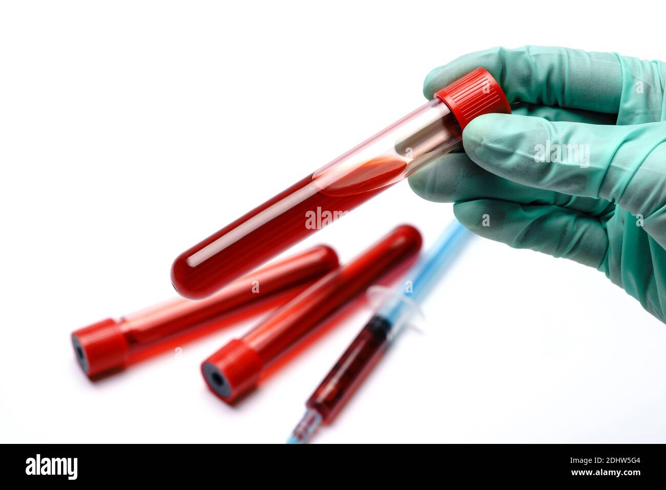 hand in latex glove holding blood sample in test tube close up isolated ...