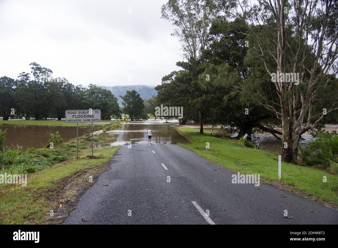 Road disappearing beneath flood waters where a river has burst its ...