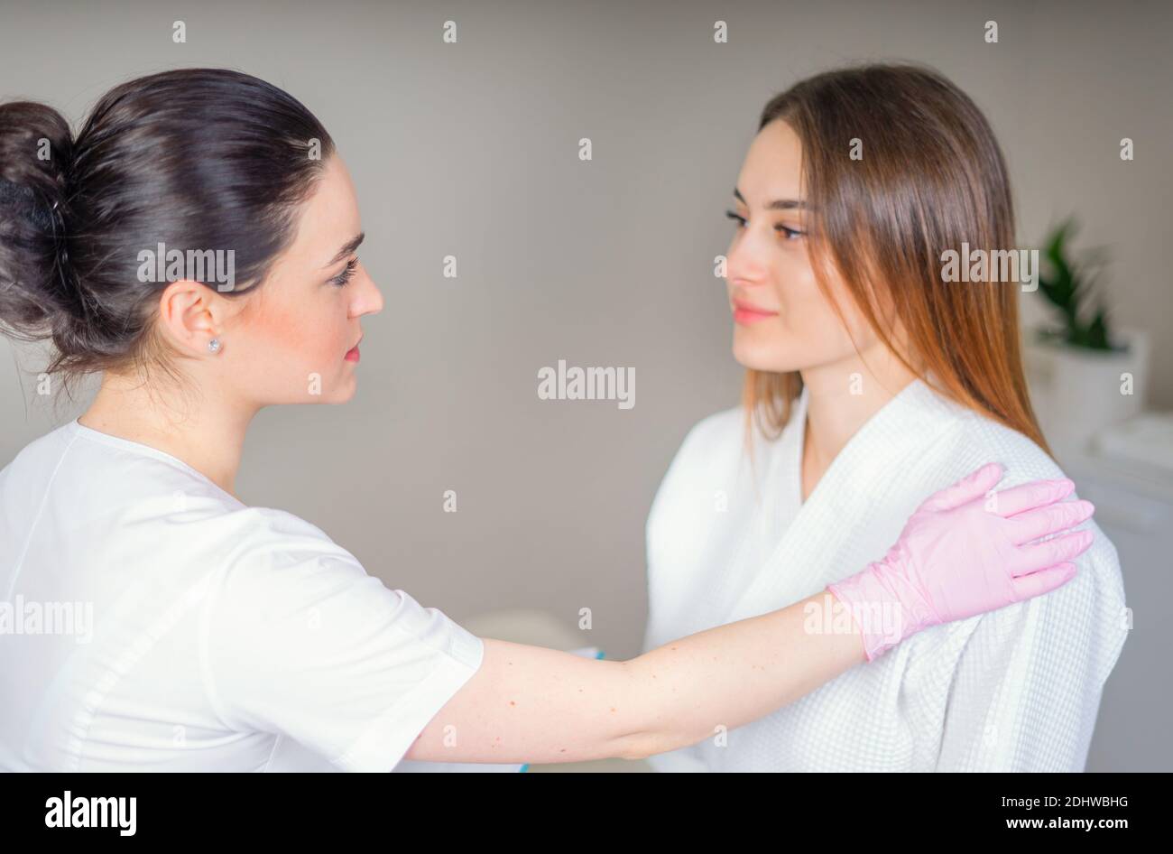 Female doctor calming down a patient at a hospital consulting room ...