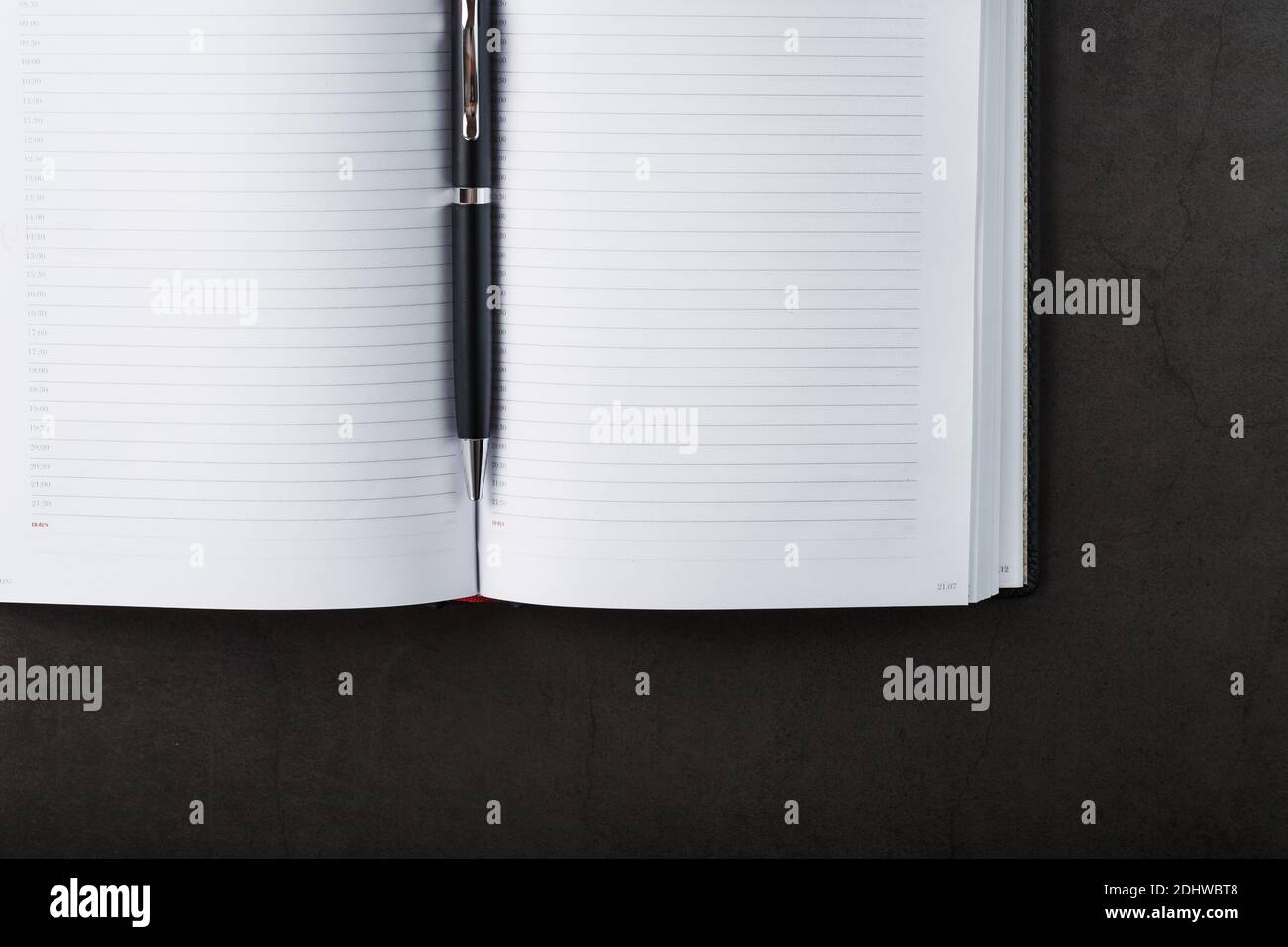Black Notepad with a black pen on a black background. Top view ...