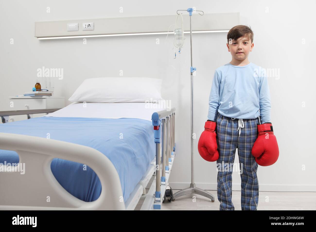 Child in hospital room with boxing gloves fighting his disease isolated ...