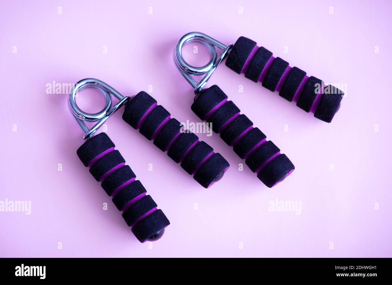 Hand grip strengthener for hand exerciser on a purple background Stock ...