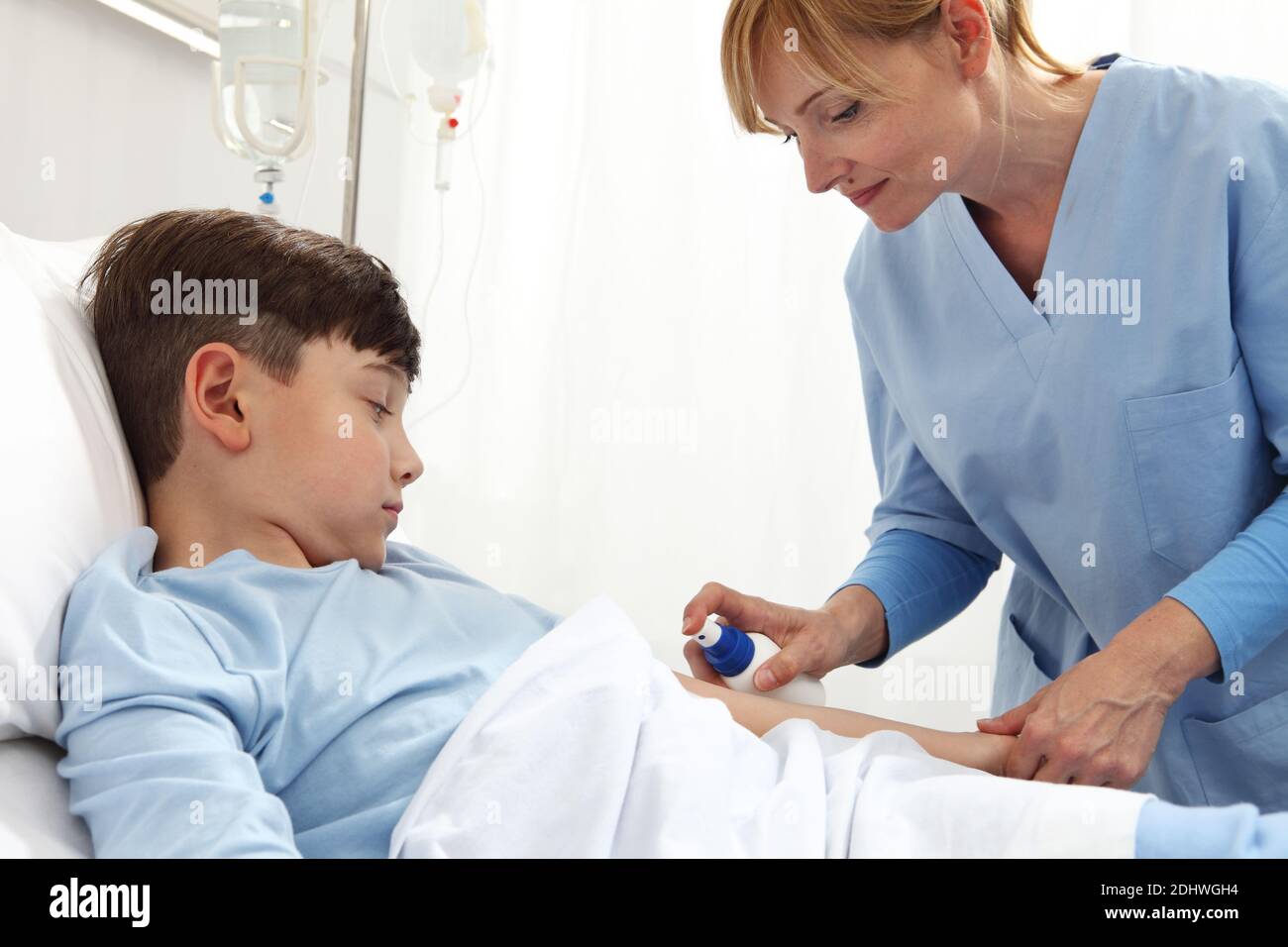 Nurse medicating sick child lying in bed in hospital room Stock Photo ...