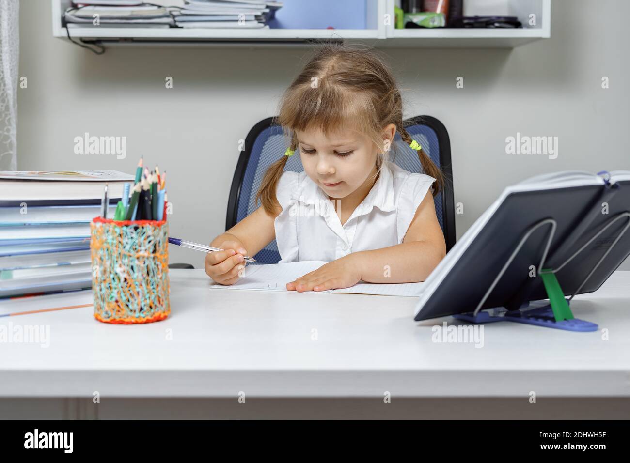 little girl doing homework at the table Stock Photo - Alamy