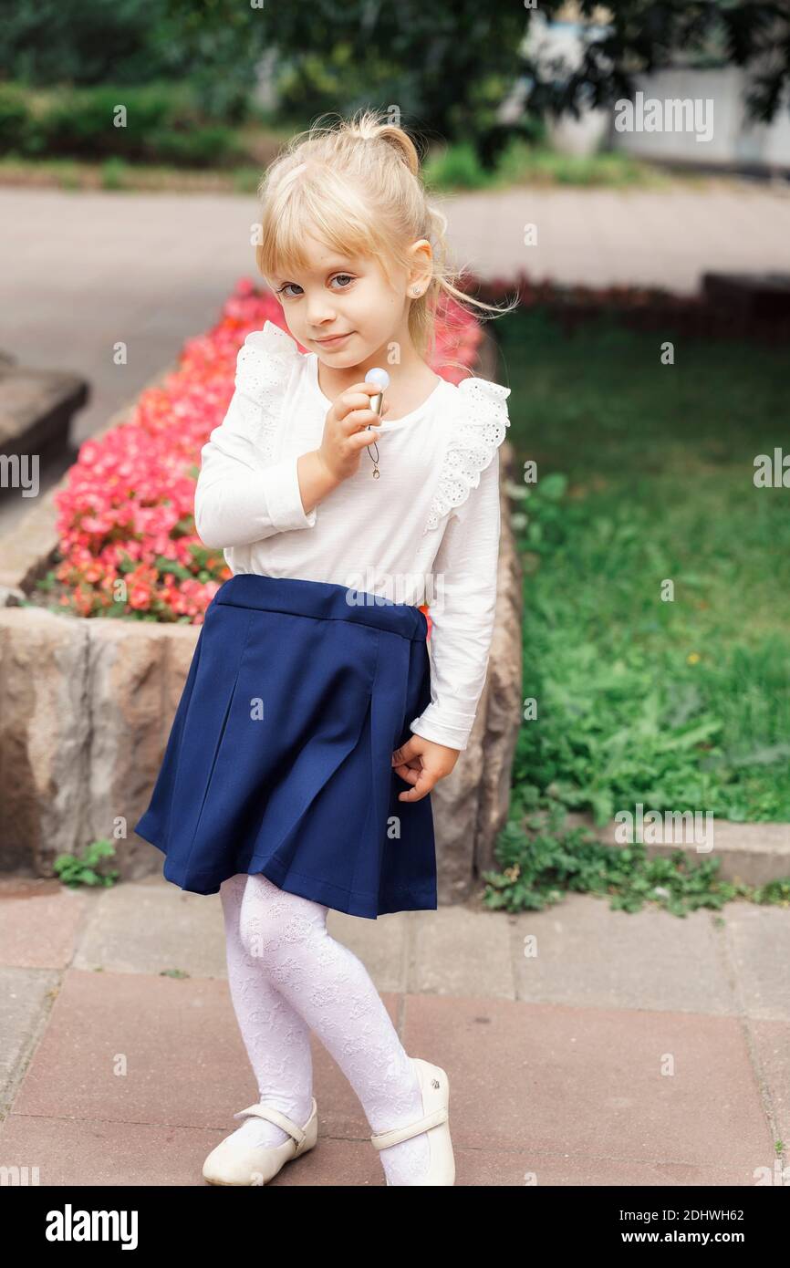 blonde little girl singing into a small flashlight like into a ...