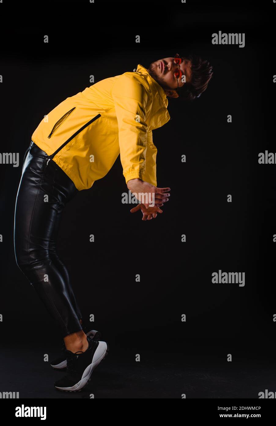 Attractive young male model posing in black pants over black wall Stock ...