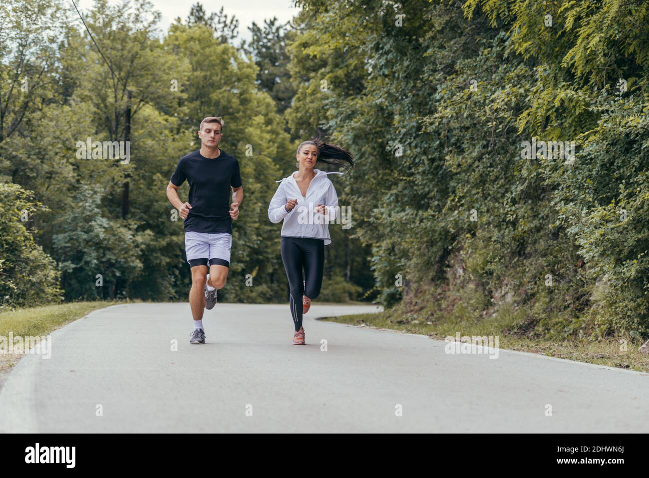 Athletic couple running on a street next to each other. Nature,fit and ...