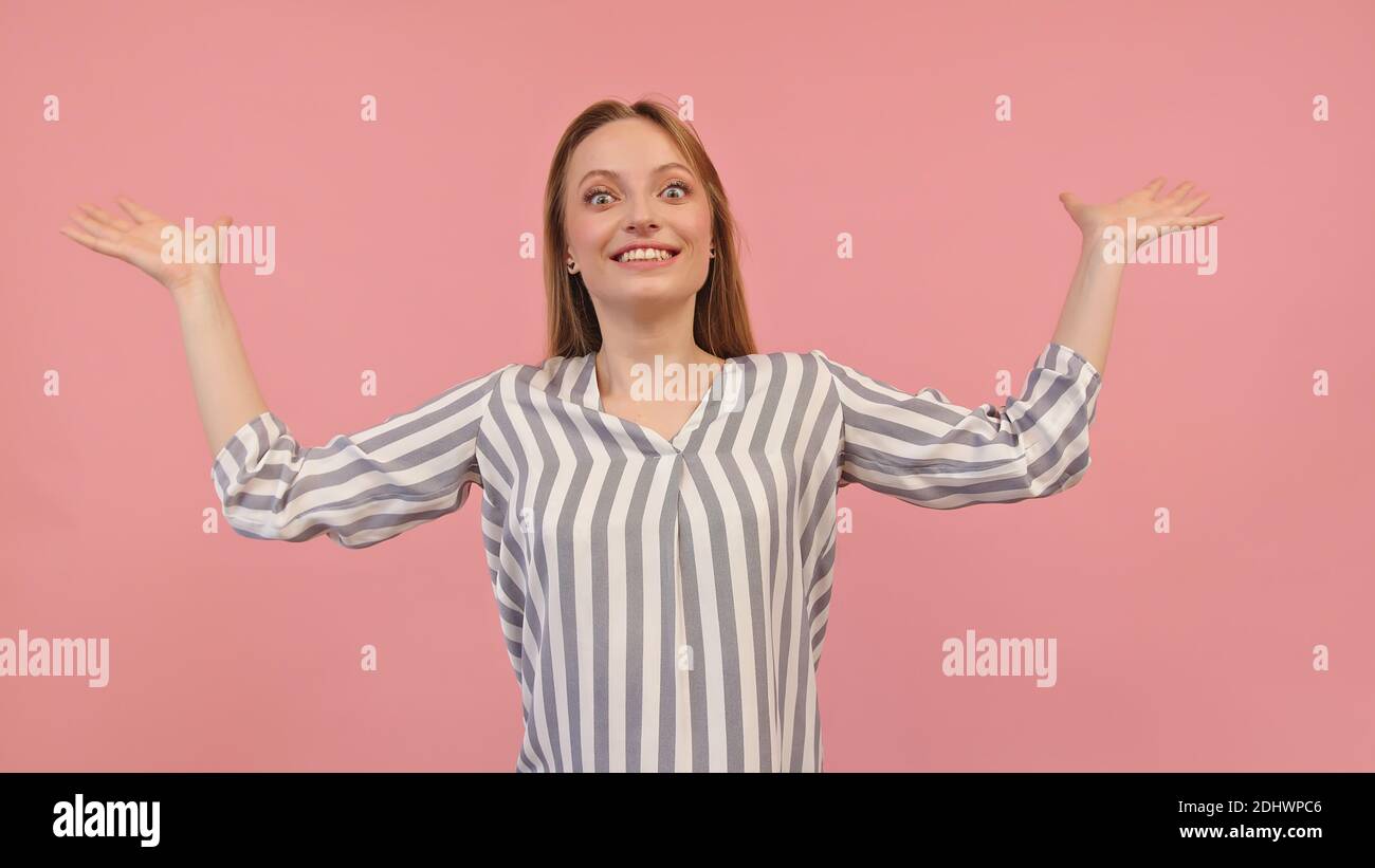 Young surprised woman with outstretched hands isolated on pink ...